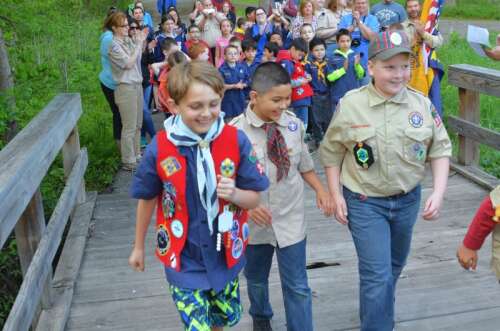 32 Aurora Scouts cross bridge in advancement ritual